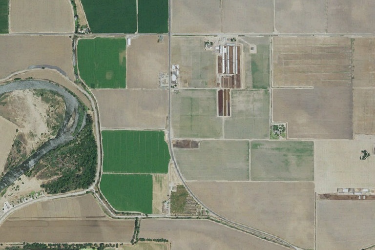 Pedestrian in yellow coat roams busy Airport Ct shoulder, San Joaquin ...
